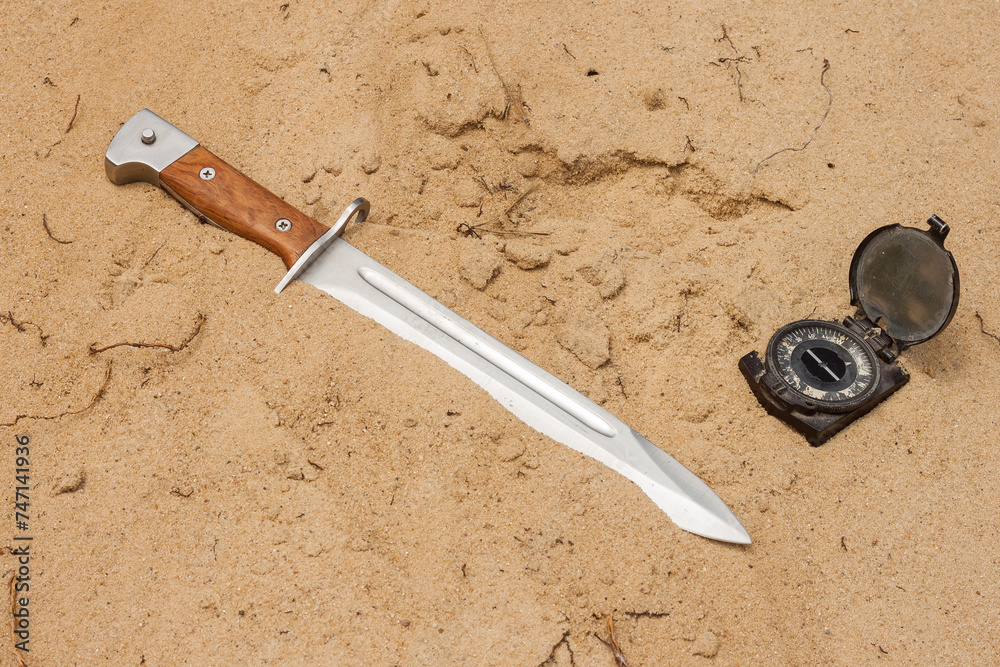 Knife bayonet with wooden handle stuck for automatic rifle in the sand ...