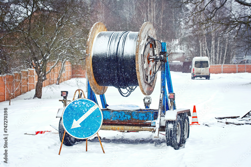 Wooden reel with fiber optic cable mounted on trailer for easy ...