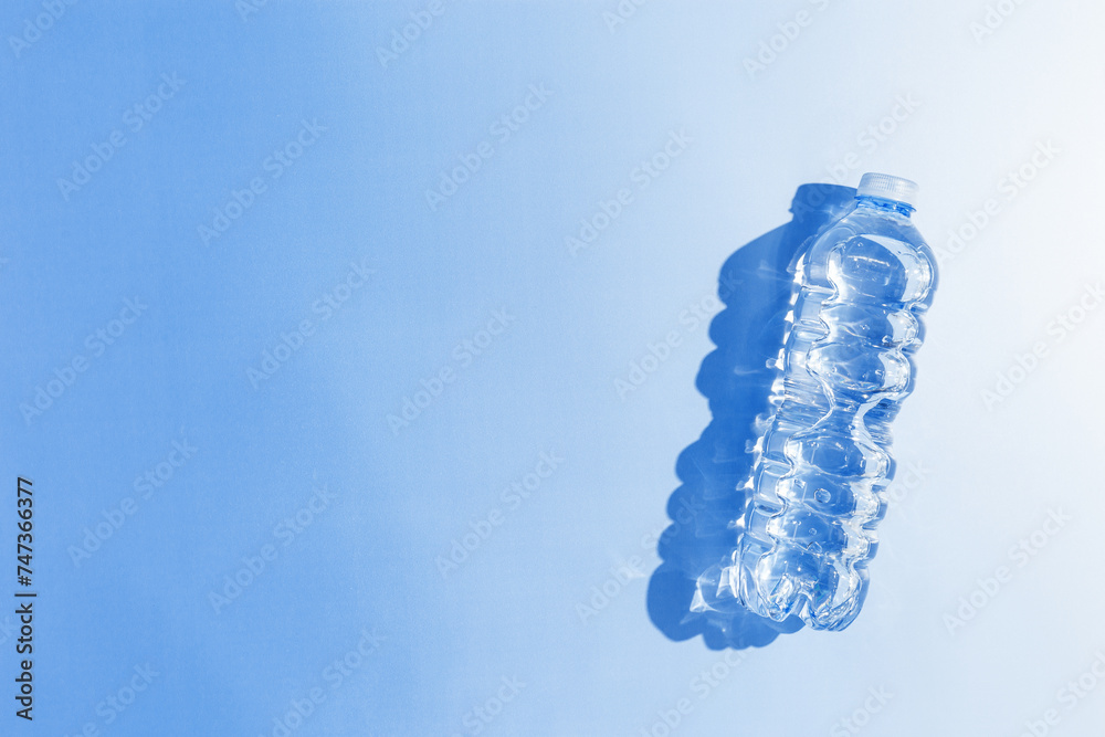 Plastic bottle water at sunlight with shadow, sun glare on blue ...
