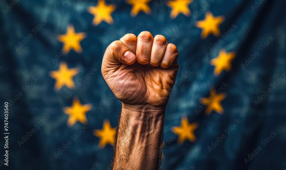 Clenched fist raised in front of the European Union flag, symbolizing ...