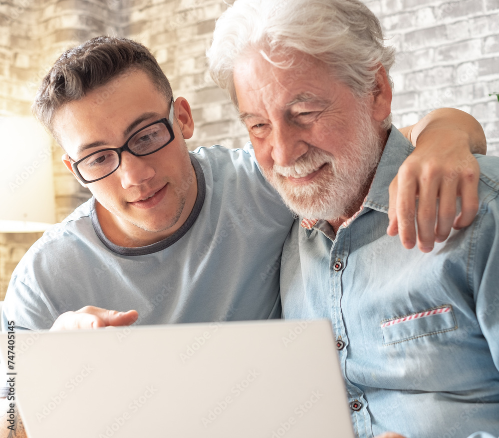 Smiling experienced young boy with laptop teaching and showing new ...
