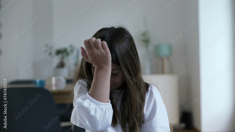 Child regretting past mistakes by covering face in shame and hitting ...