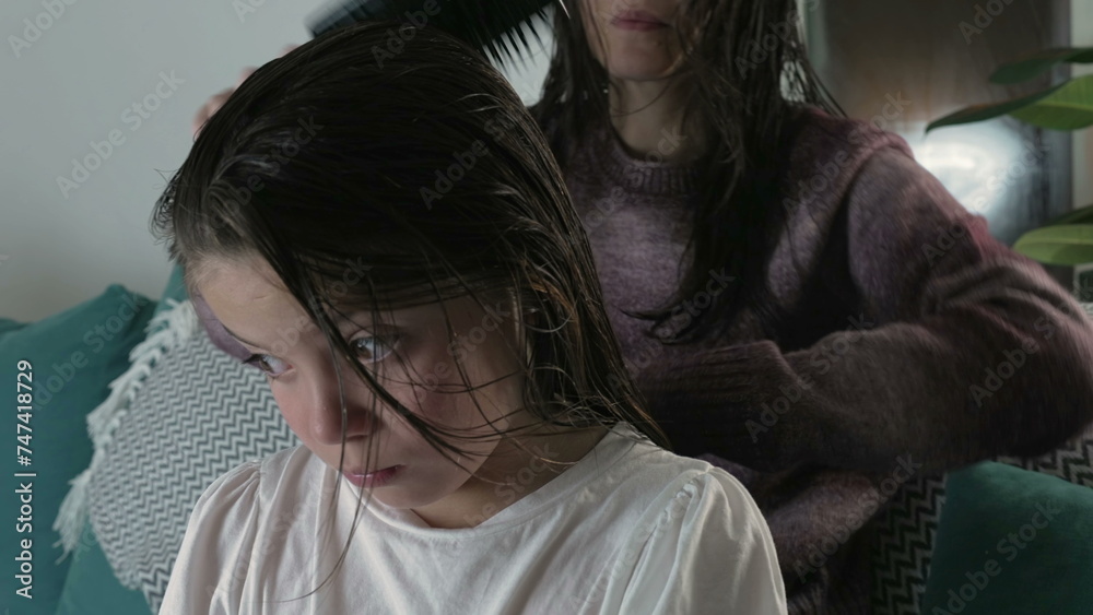 Mother combing daughter's hair at night before bedtime. Authentic ...