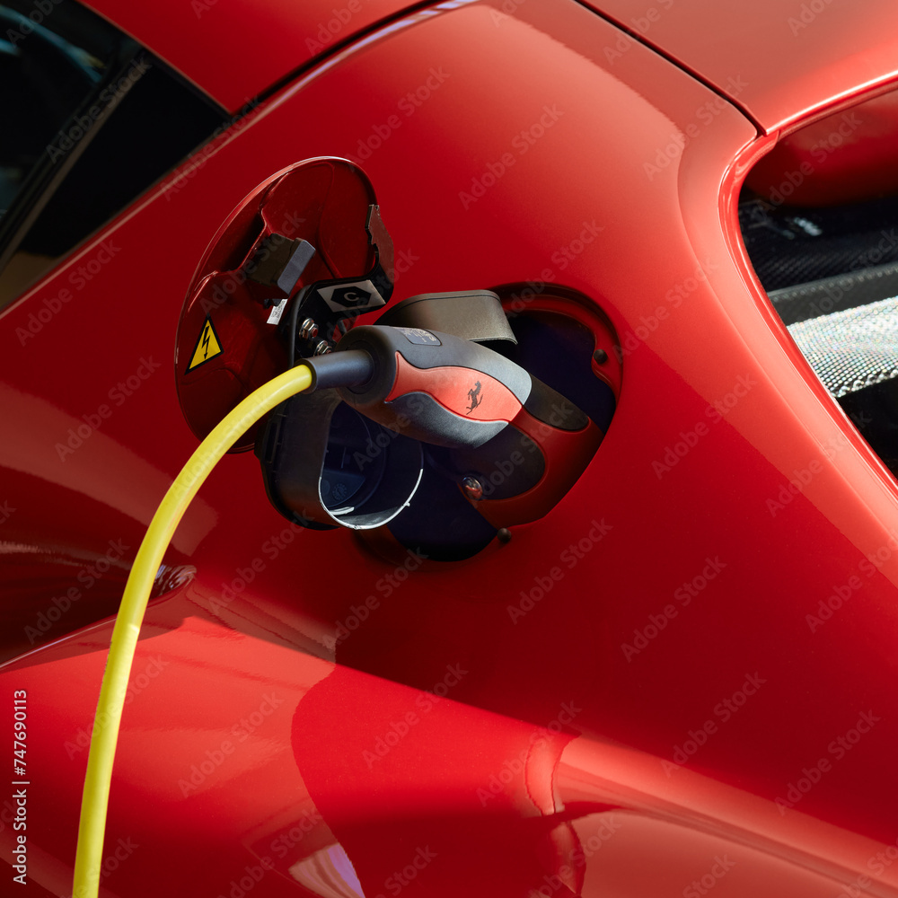 Charging a Ferrari 296 GTB plug-in hybrid, plug detail. 2.9L, V6 engine ...