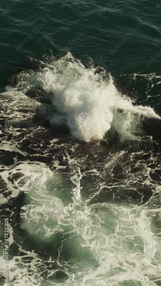 Vertical video. Rocky with steep cliffs, the seashore, huge rocks and ...