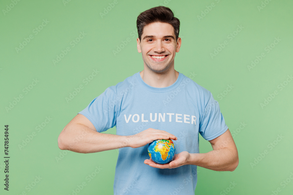 Young smiling man wearing blue t-shirt white title volunteer hold in ...