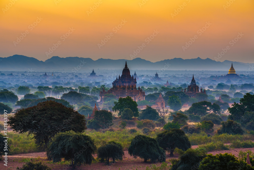 Sunrise over the ancient temples of Bagan with distant mountains ...