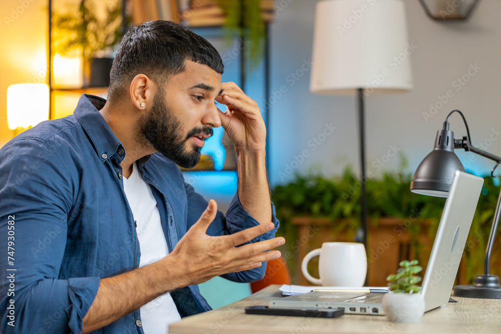 Angry furious Indian Arabian man freelancer using laptop while working ...