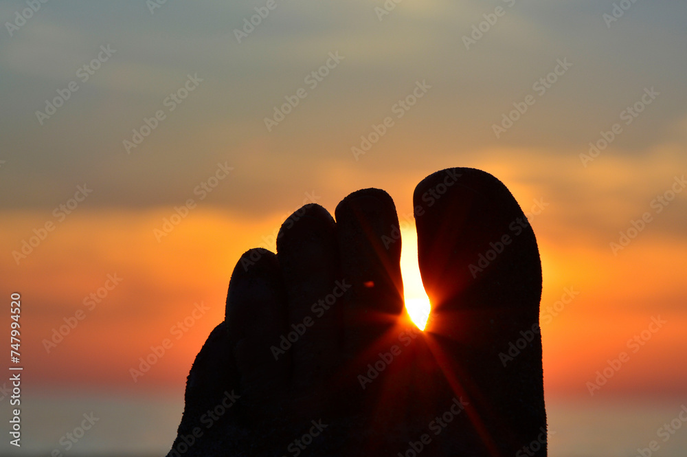 stopa i zachód słońca nad morzem, relaks na plaży o zachodzie słońca ...