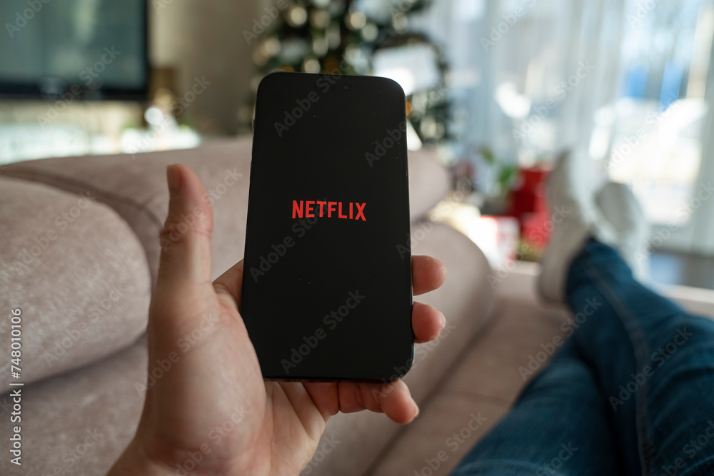 Man holding an iPhone 14 Pro Max smartphone with Netflix app in his ...