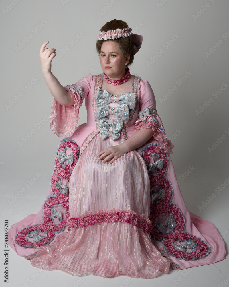 Fun length portrait of female model wearing an opulent pink gown ...