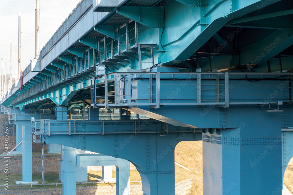 Parts of a modern metal bridge in close-up against a blue sky ...