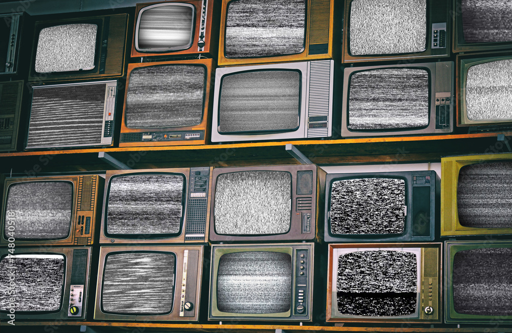 Wall of old wooden black and white TV screens, static noise caused by ...