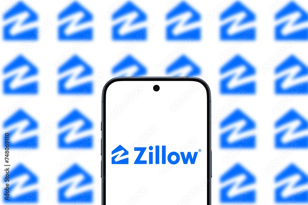 Zillow logo is displayed on a smartphone, blue Zillow Logos in the ...