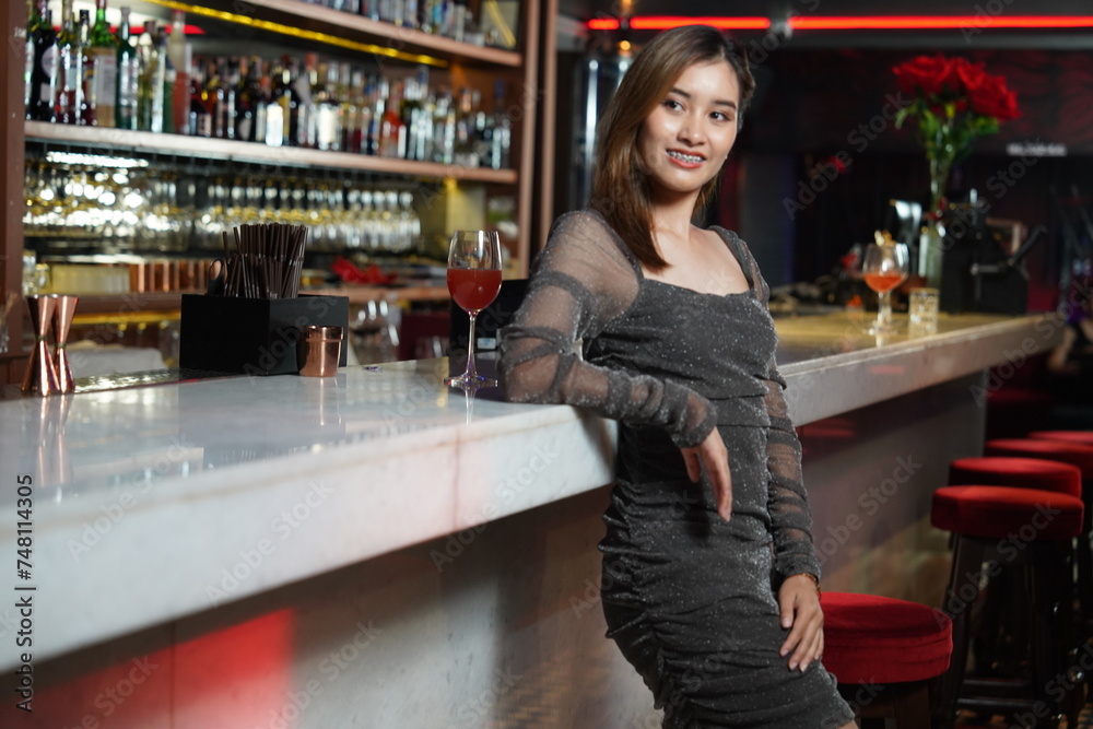 Asian women, friends wearing dresses, standing at the bar counter with ...