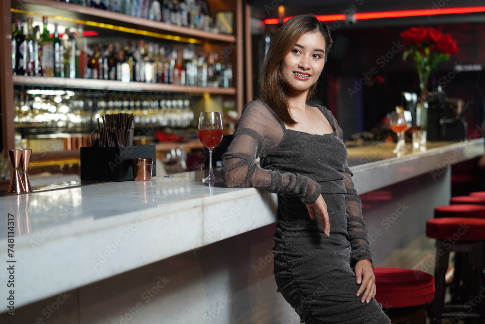 Asian women, friends wearing dresses, standing at the bar counter with ...