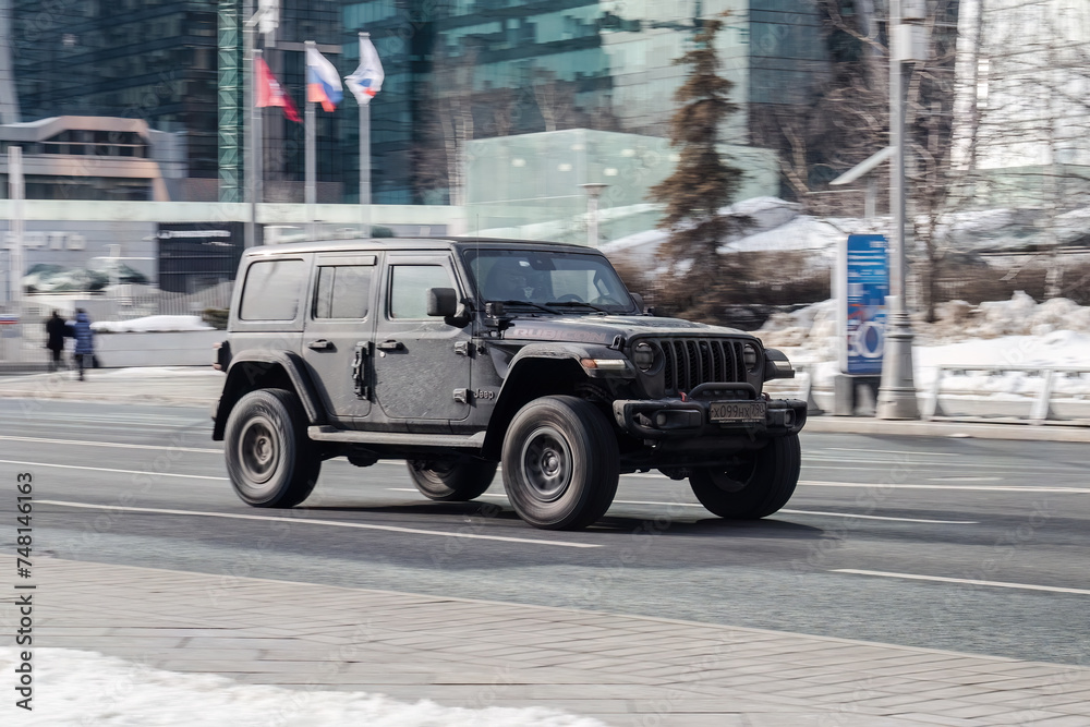 Jeep Wrangler Rubicon is driving in the cityscape. Front side view of ...