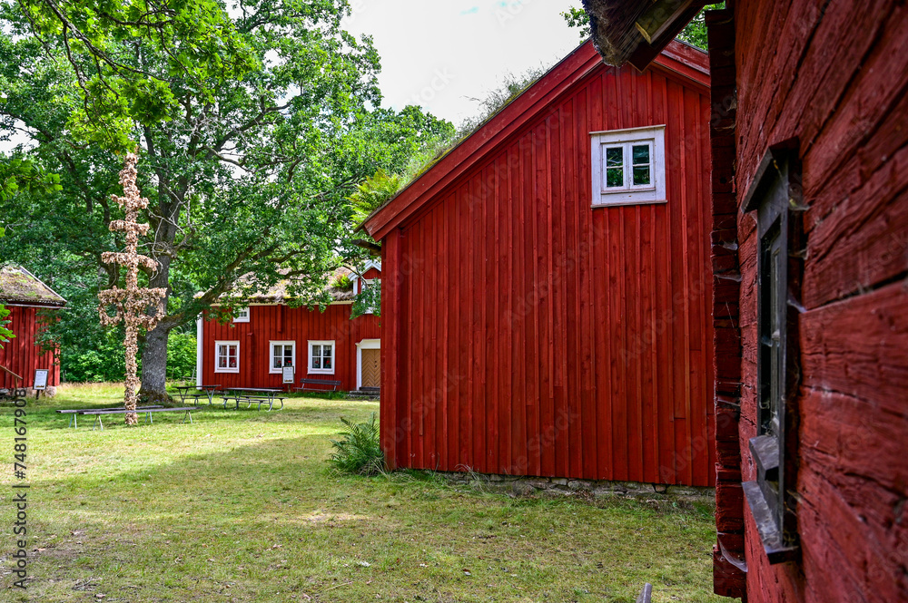 typical, traditional red Swedish house, wooden house with a mossy roof ...