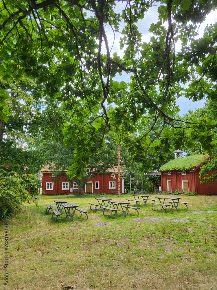 typical, traditional red Swedish house, wooden house with a mossy roof ...
