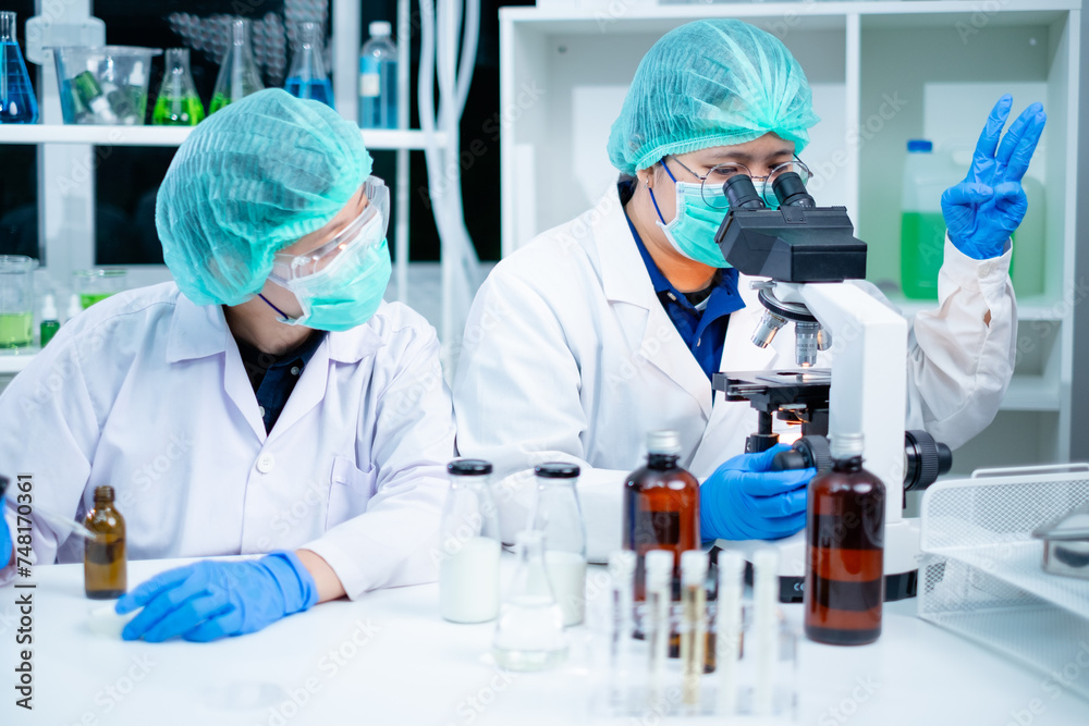 Nutritionist or scientist is using microscope to check the quality of ...