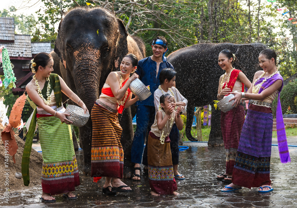 Group of Thai people and children in traditional Thai costumes holding ...