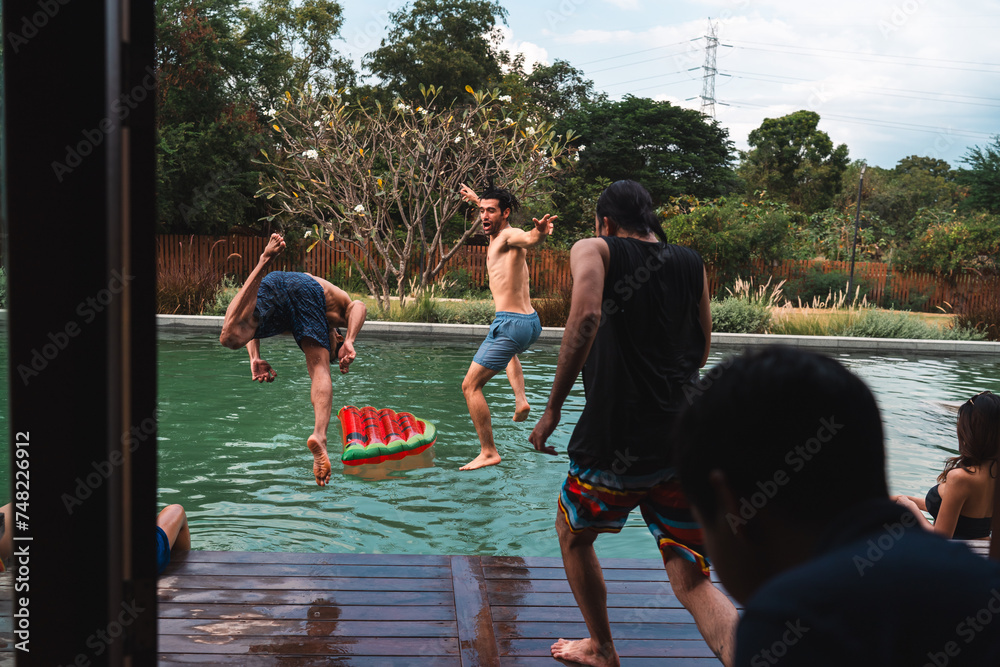 happy friend group having holiday party together at swimming pool water ...