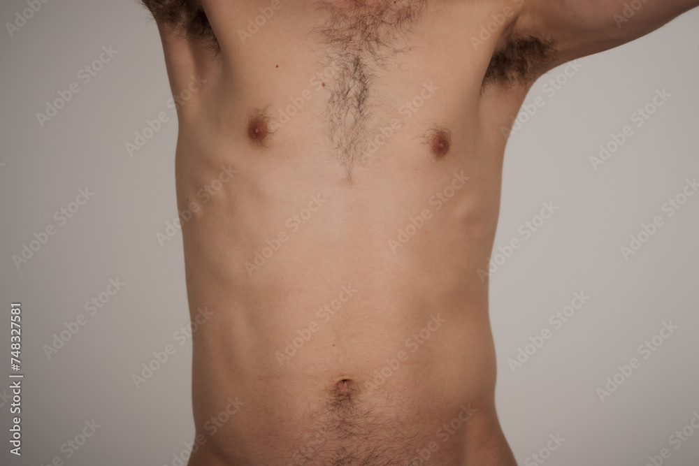 The torso of a shirtless man with his arm raised, showing muscle ...