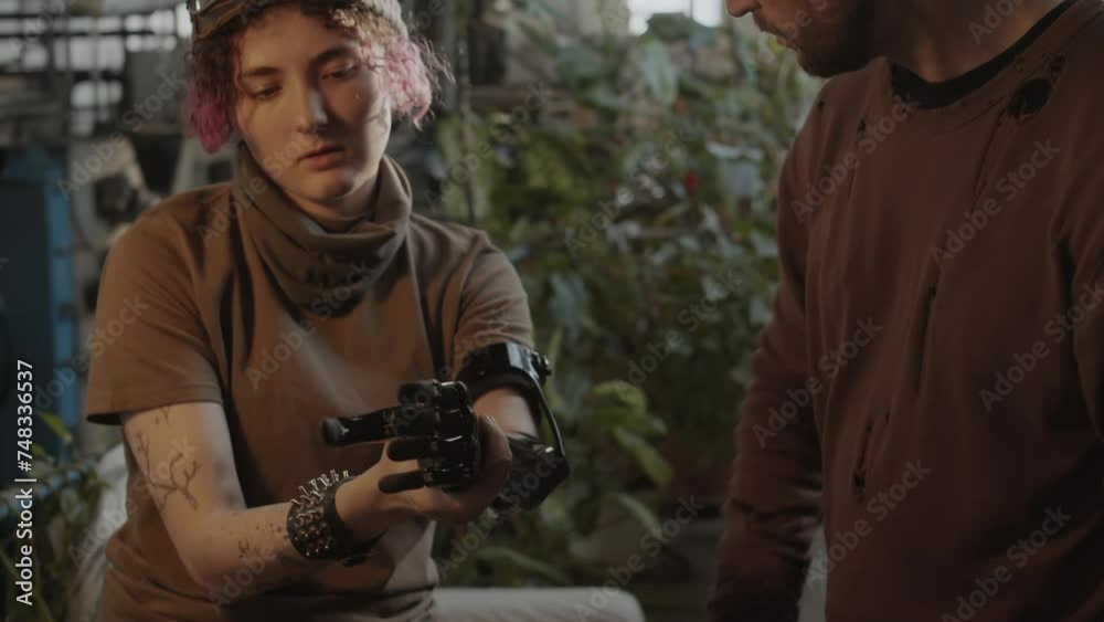 Tilt up shot of young girl putting on prosthetic arm fixed by her ...