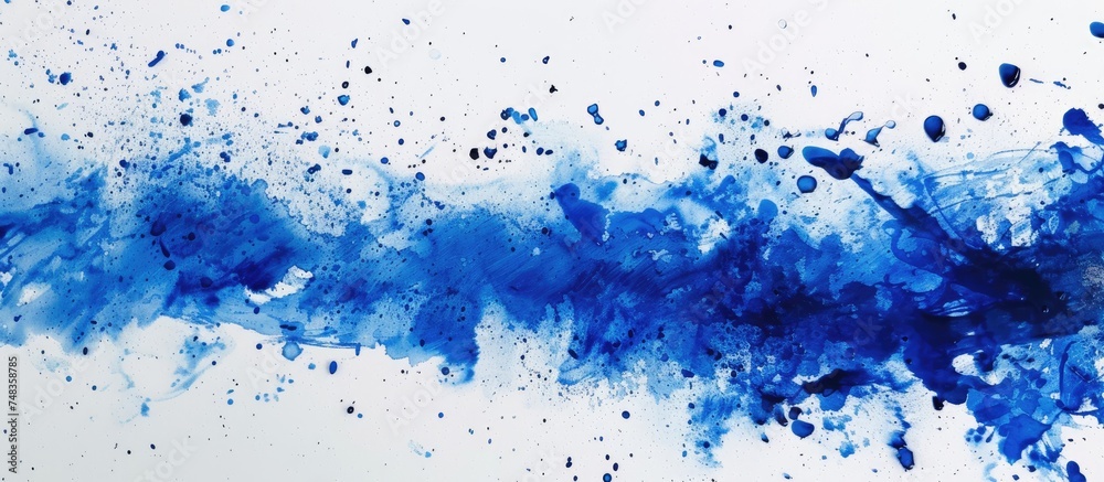 A close-up view of vibrant blue ink splattered in various shapes and ...