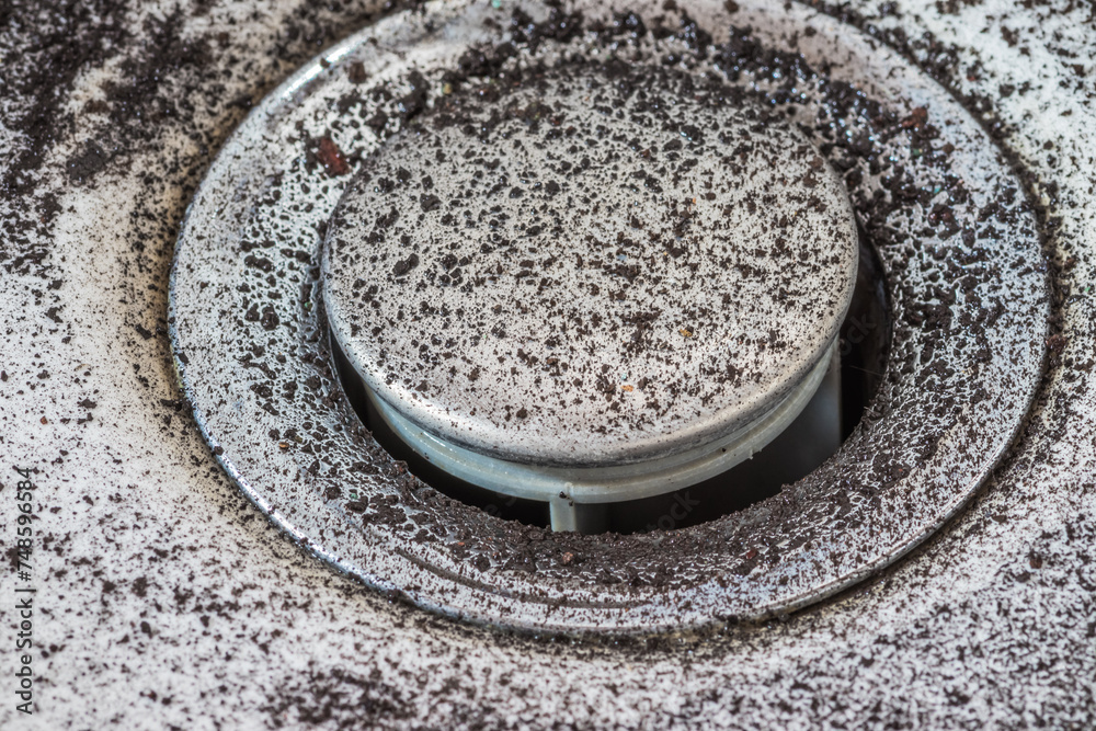 Falling dirty particles from a water filter in a white washbasin ...