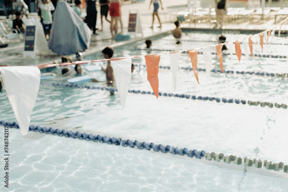 Toned photo backstroke flags and blurred swimming class little kids ...