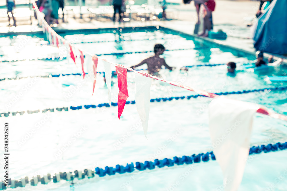 Backstroke flags and blurred swimming class for little kids with coach ...
