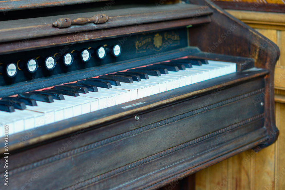 An antique church organ with ivory and black keys, pedals, controls ...