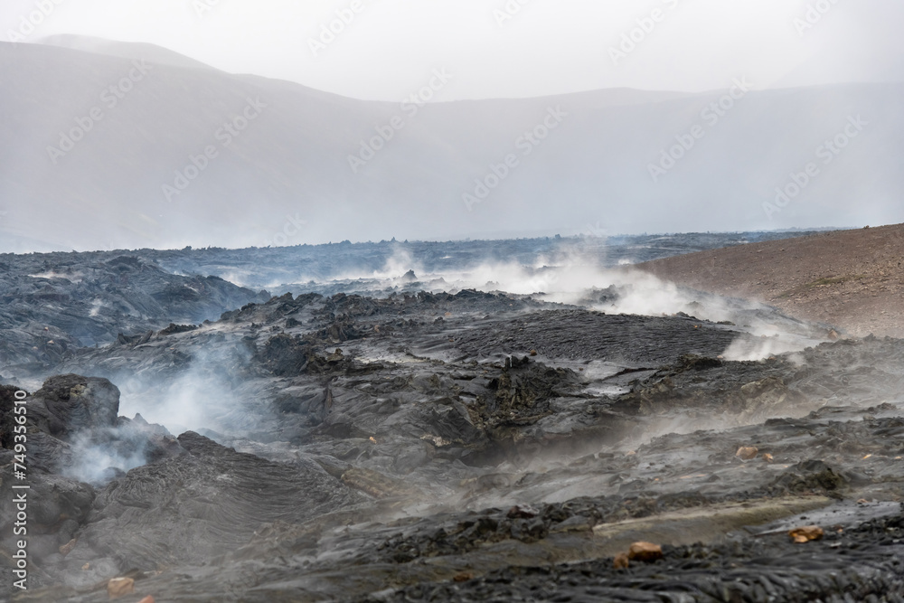 Close up view of cracked lava crust or ingenious rock and steam, cooled ...