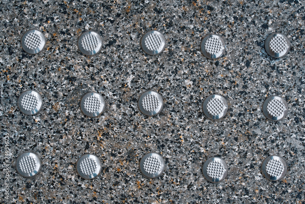 Stainless steel tactile ground surface indicators set in stone paving ...