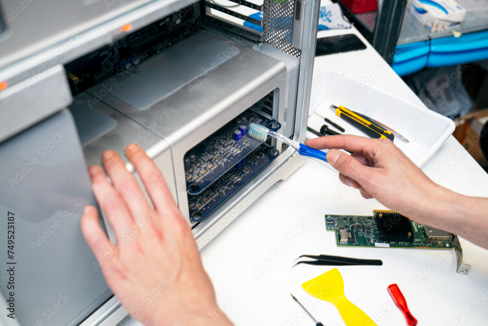 Tech expert securing a motherboard inside a case. Stock Photo | Adobe Stock