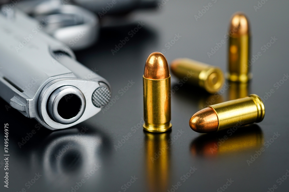 Short pistol and ammunition put on a black desk background with shadow ...