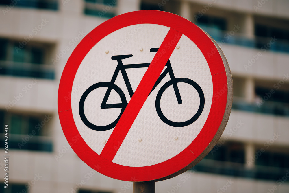 A red and white traffic sign with bold font that prohibits bicycles ...