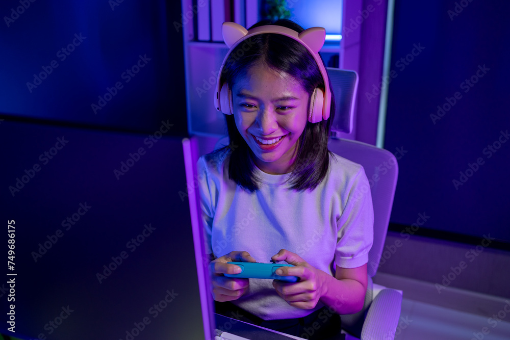 Fotografia do Stock: A beautiful female gamer happily plays in a ...