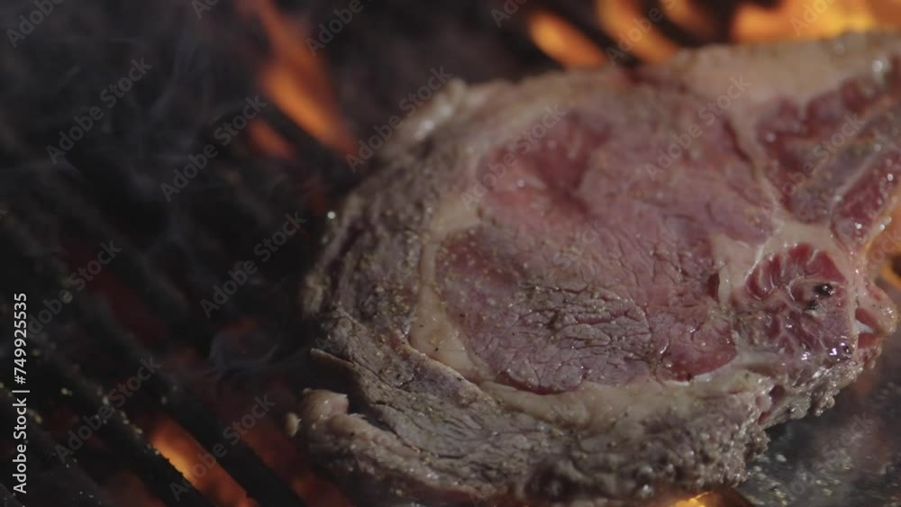 Roast beef with fire flames. Beef steak on grill with flames. Rib-eye ...