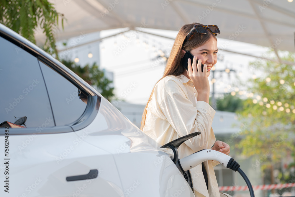 Sustainable urban commute with young woman pay electricity for EV ...