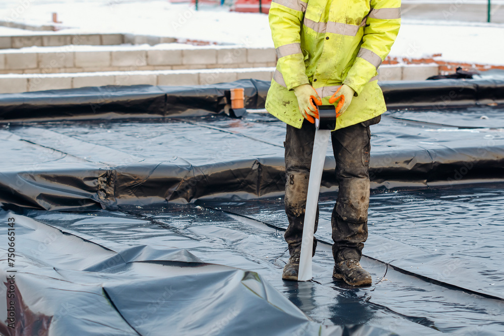 Waterproof installation at new house construction. Builders installing ...