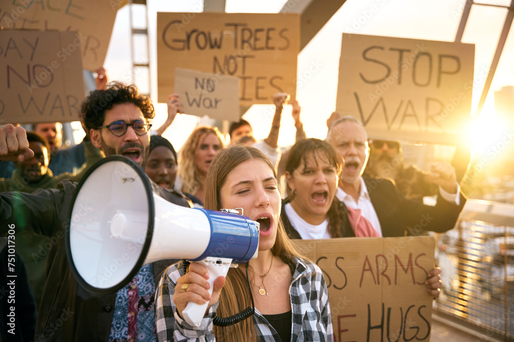 Blonde woman with megaphone in protest with diverse group activist ...