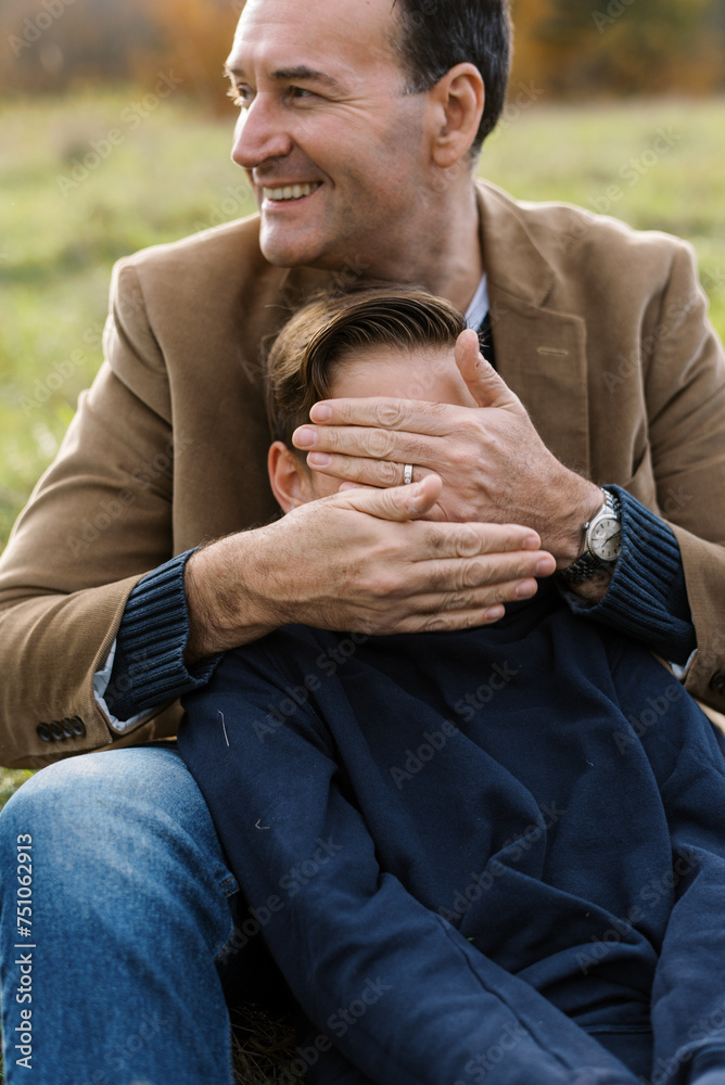 smiling and happy middle aged father and his son sitting outdoors Stock ...