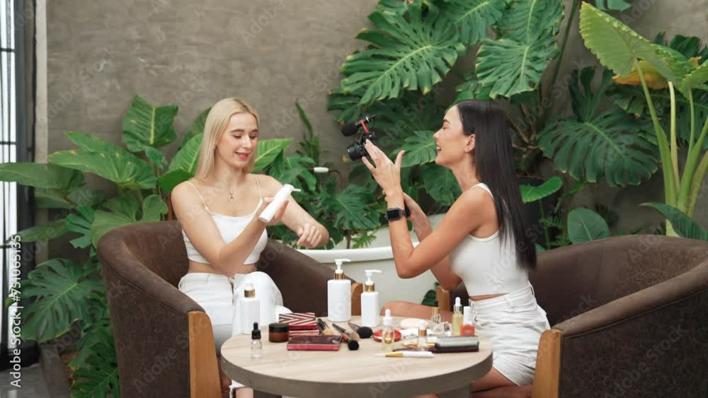 Two beautiful content creator making natural beauty and cosmetic tutorial on green plant leave ...