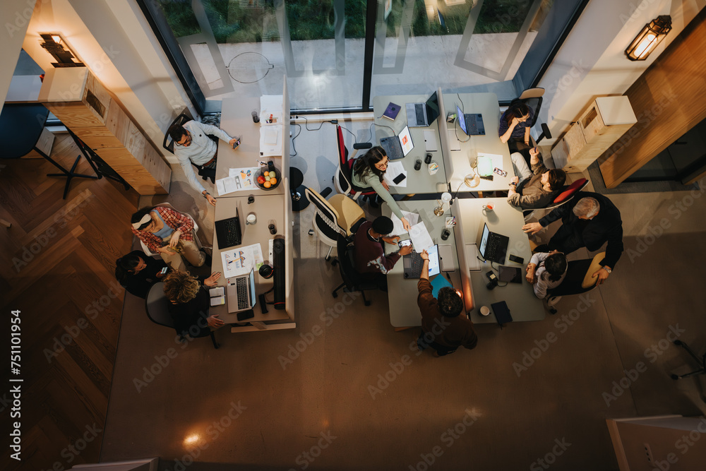 Top view of a multi-generational, mixed-gender team discussing strategy ...