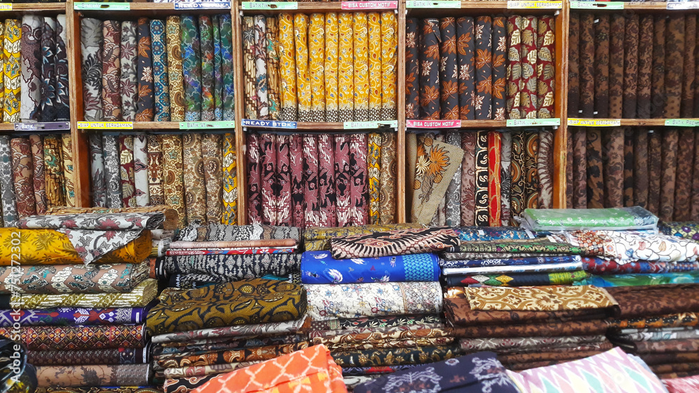 Stacking piles of batik cloth clothes in a batik shop. Batik is ...