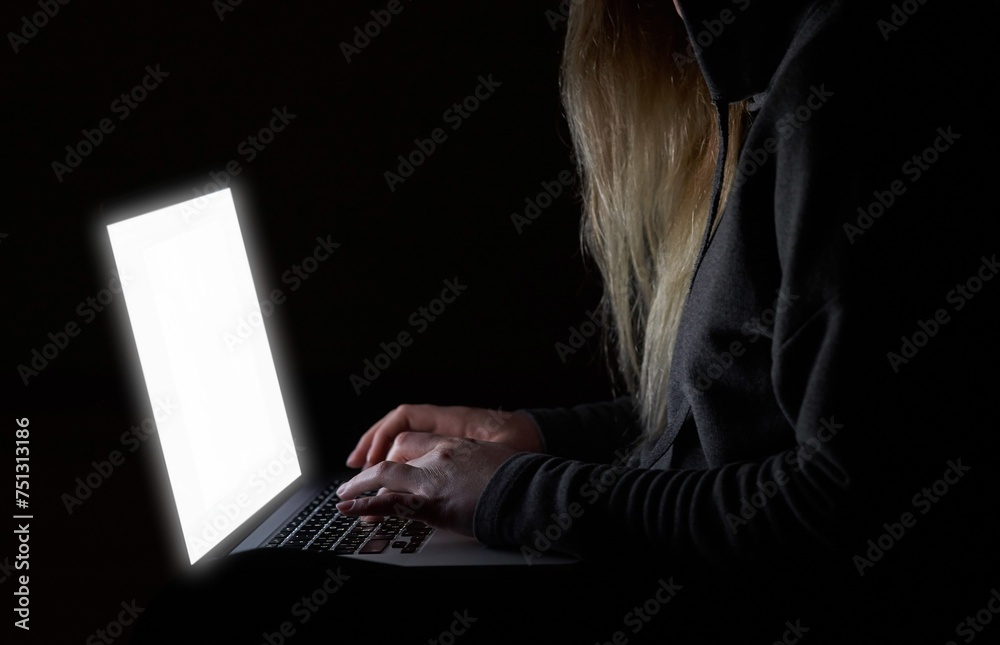 Overhead hacker in the hood working with laptop and mobile phone typing ...