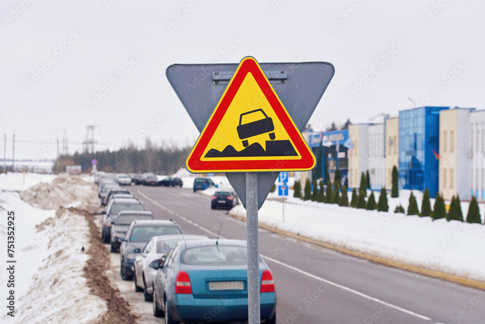 Soft verges. Warning sign, traffic sign and cars parked in row along ...