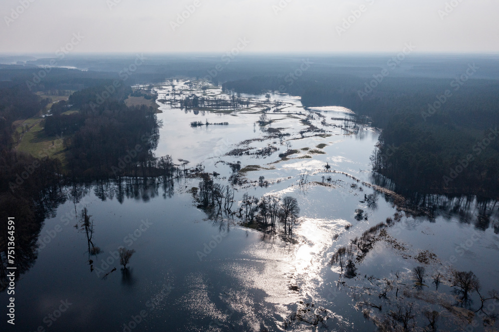 Flooded fields, meadows and forests during excessive rainfall. A river flooding fields and ...